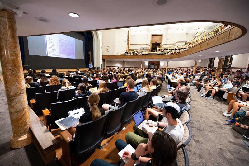 UI students listening in a large lecture course in Macbride Auditorium.